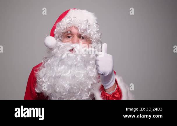 Happy santa claus looking at the camera giving thumbs up in front of a ...