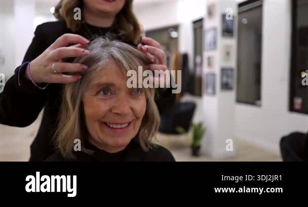 Happy senior woman getting her hair styled by a professional ...