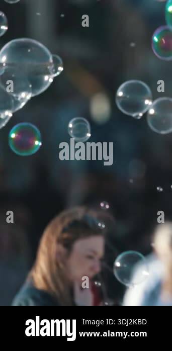 Iridescent soap bubbles float and pop against the backdrop of a lively ...