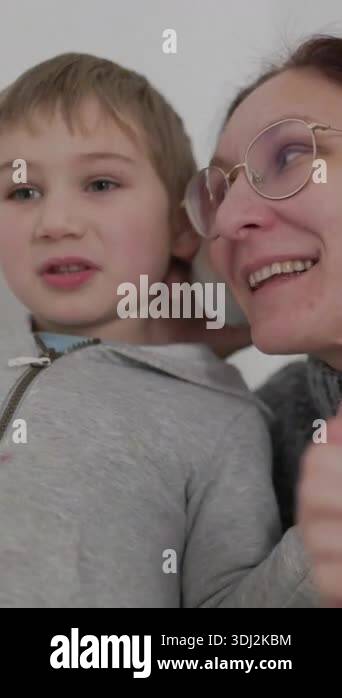 Happy mother and son listening to music with headphones, sharing a ...