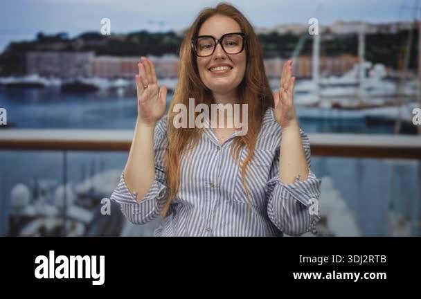 Redhead woman wearing glasses and striped shirt framing gesture with ...