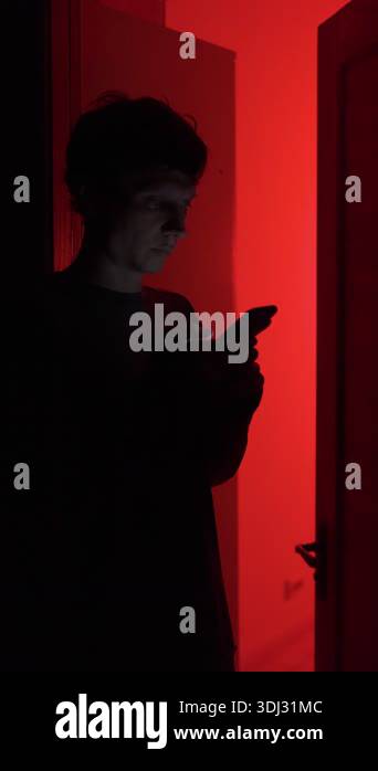 Man emotionally affected by bad news on phone, standing in doorway ...