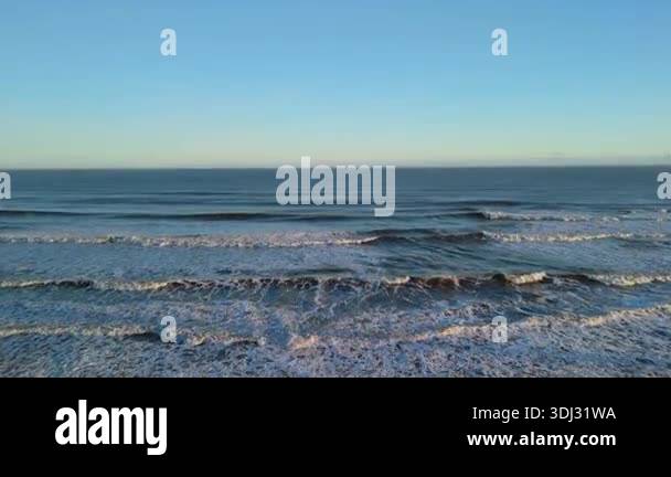 Waves crash on the shore in Blyth, Northumberland as the sun sets in ...