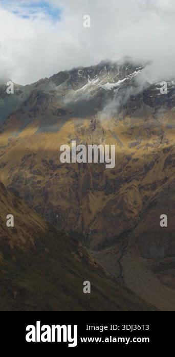 Vertical panning shot of high mountain peaks in the Andes. Sunlight ...
