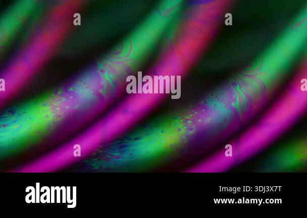 Defocused emulsion spill. Circling fluid. Purple pink green color paint ...