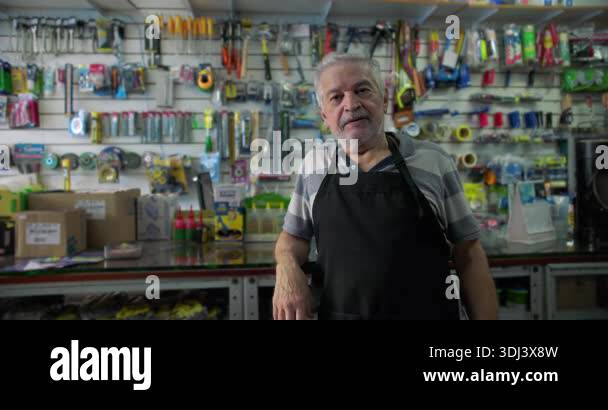 Hardware store owner inside shop communicating approachability ...