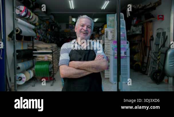 Friendly hardware store owner facing camera smiling communicating ...