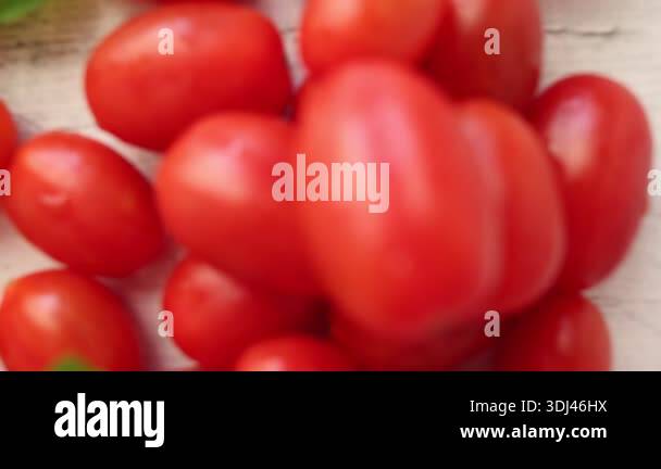Cherry tomatoes spilling from glass jar on white wooden table.Fresh red ...
