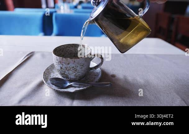 Carelessly pour spilled tea into a cup in restaurant, slow motion Stock ...