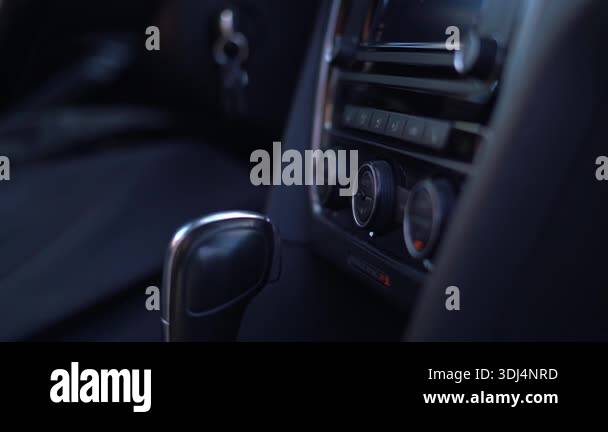 Close up of hand adjusting climate control knob on car dashboard ...