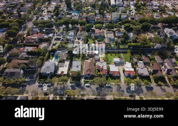 Cinematic aerial view of dense residential blocks with trees and ...