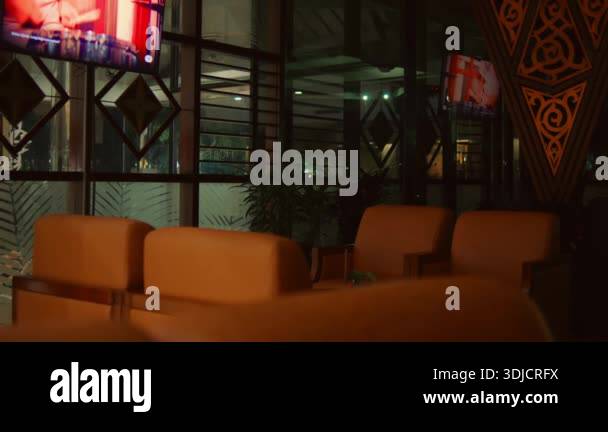 Comfortable orange sofas in a dimly lit hotel lobby featuring ...