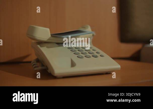 High angle view focusing on a stationary white telephone and a small ...