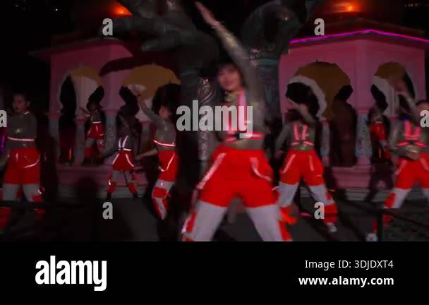 Front view of a dynamic female dance troupe in futuristic red and ...
