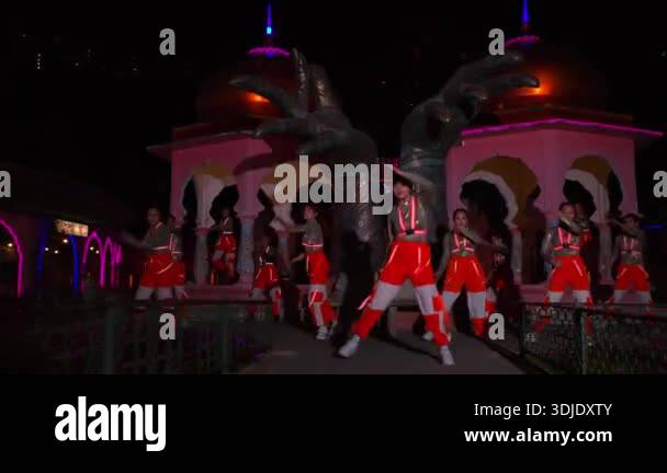 Wide shot of a female dance crew in matching red and silver costumes ...