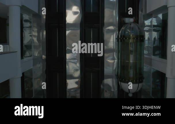 A ride in a modern glass elevator as the camera pans smoothly capturing ...