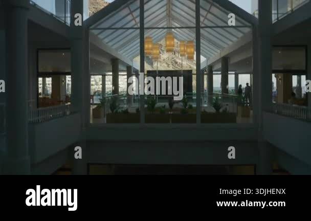 A ride in a modern glass elevator as the camera pans smoothly capturing ...