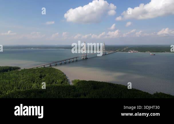 A long bridge stretches across a large body of water, connecting two ...
