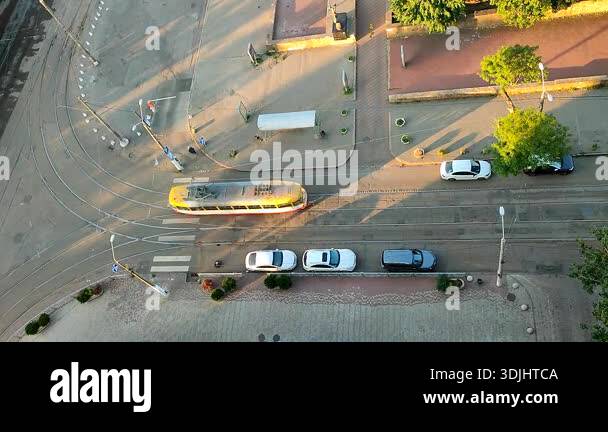 Passing tram at road intersection. Road, tram, people, parked cars ...