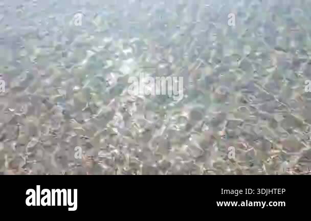 Clean transparent water on shallow sandy seashore with shells with ...