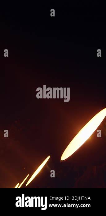 Vertical video. Row of Bright Spotlights Pointing Upward into Dark ...