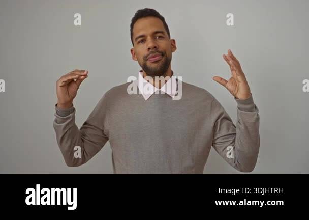 Young hispanic man making expressive hand gestures against a plain ...