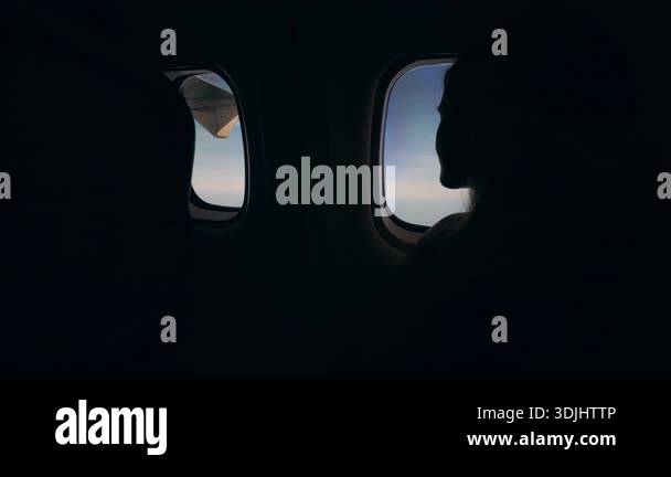 Silhouette of Woman Looking Out Airplane Window at Sky and Wing ...