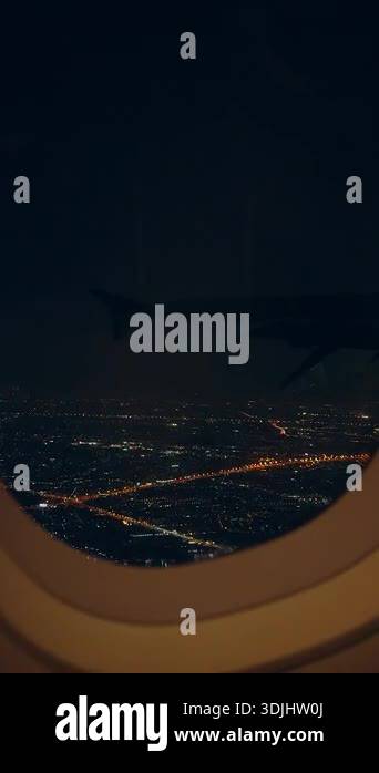 Vertical video. Low Angle Aircraft Window Scene showing City Lights ...