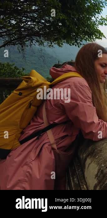 Vertical video. Medium View of Woman Leaning on Stone Railing with ...