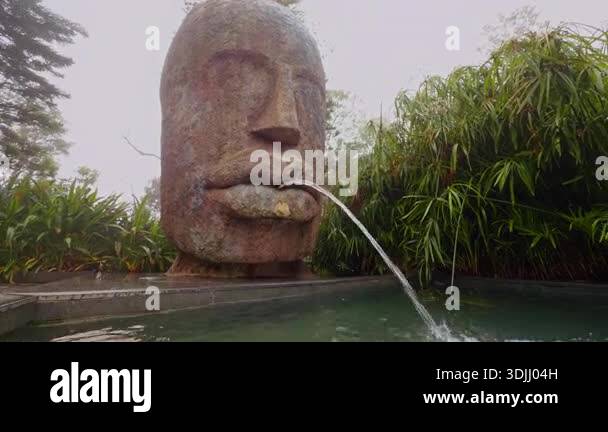 Massive Stone Face Fountain Pouring Water Into Pool with Foggy Garden ...