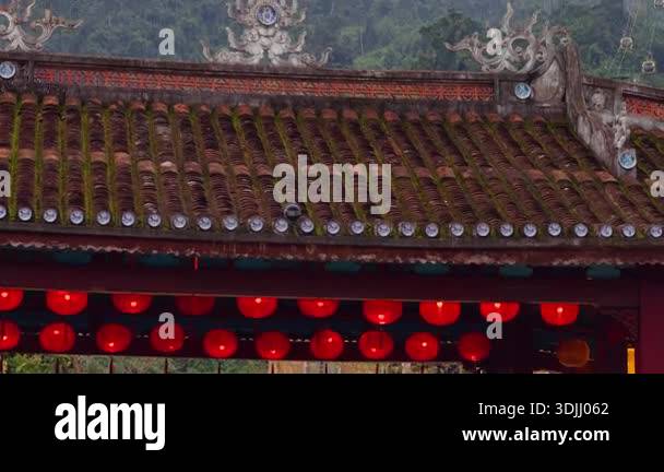 Old Tiled Roof With Moss and Red Lanterns Beneath Forested Hills and ...