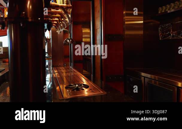 Bar Counter With Polished Copper Beer Taps and Dark Surfaces Under Warm ...