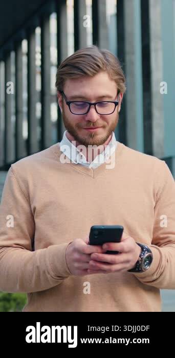 Happy young red bearded man in casual wear walking with modern ...