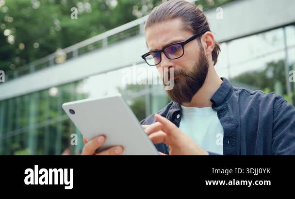 Close up of focused businessman analyzing financial data on a tablet ...