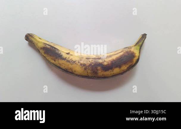 Ripe banana with natural brown spots isolated on a white background ...