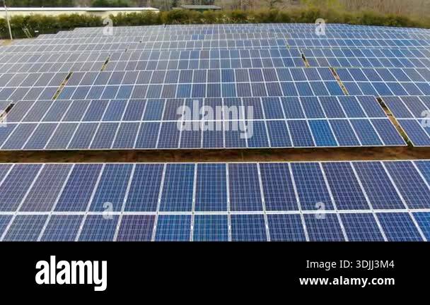 High-angle perspective of a massive solar energy farm. Long rows of ...
