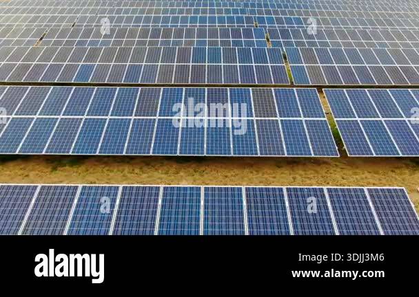 High-angle perspective of a massive solar energy farm. Long rows of ...