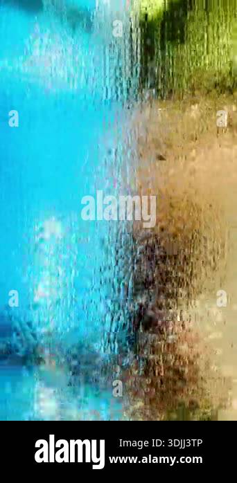 Abstract background of water flowing down textured glass, creating soft ...