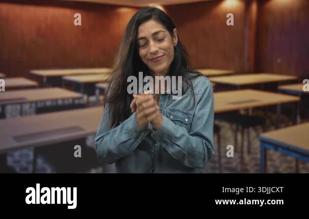 Young woman clapping with smiling face in classroom while speaking and ...