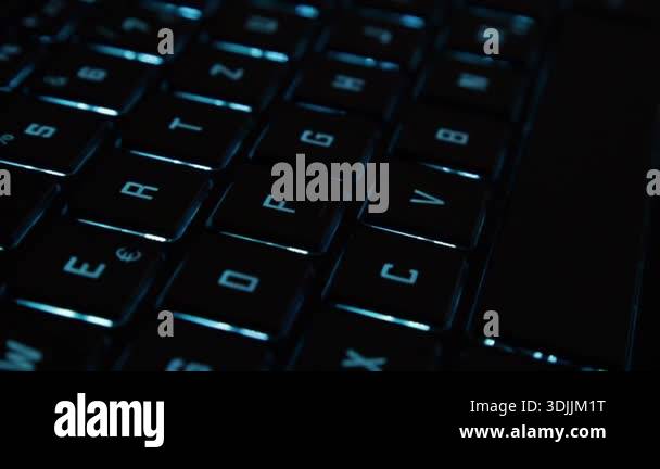 slide view over blue glowing notebook computer keyboard technology in ...