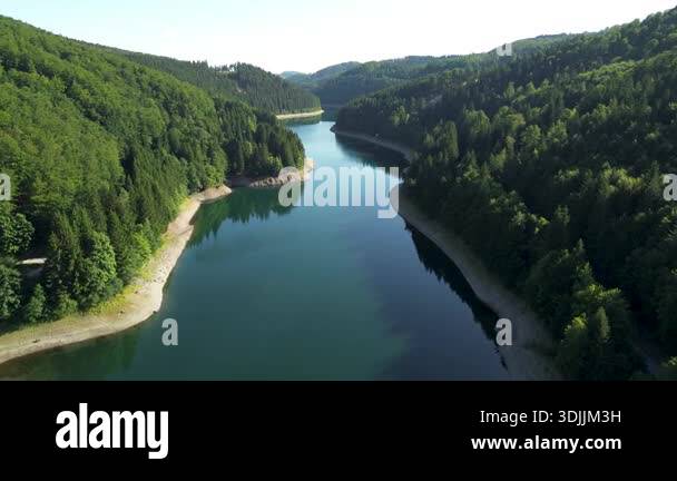 high flight over beautiful blue water river in spruce tree covered ...