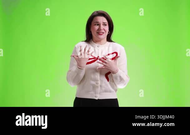 Young woman smiling uncomfortably and gesturing with open hands on ...