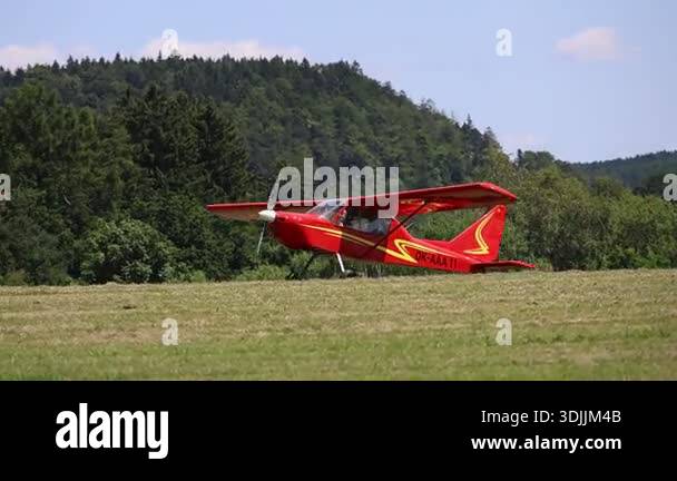 Bright Red Sport Aircraft with Running Engine Taxiing Across a Mown ...