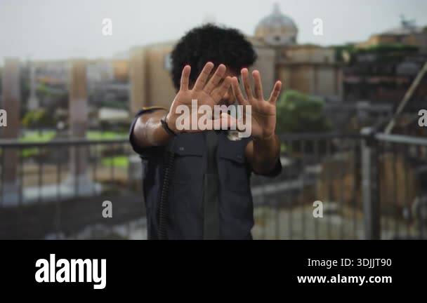 African american man in police uniform makes stop gesture amidst ...