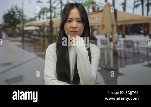 Woman standing outdoors on a restaurant terrace street with a ...