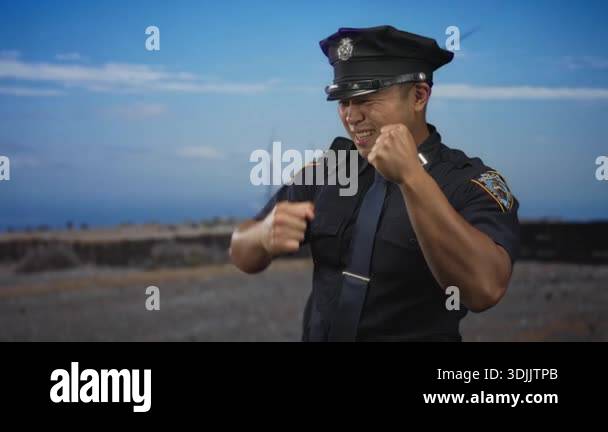 Young chinese policeman in uniform raises clenched fists beside a ...