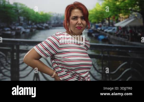 Woman holding lower back for backache on a street bridge in amsterdam ...
