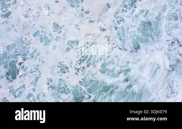 White wash and spray from the sea Top down aerial of chaotic ocean foam ...