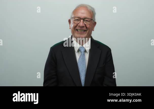 Senior man in business suit pointing and smiling against white ...