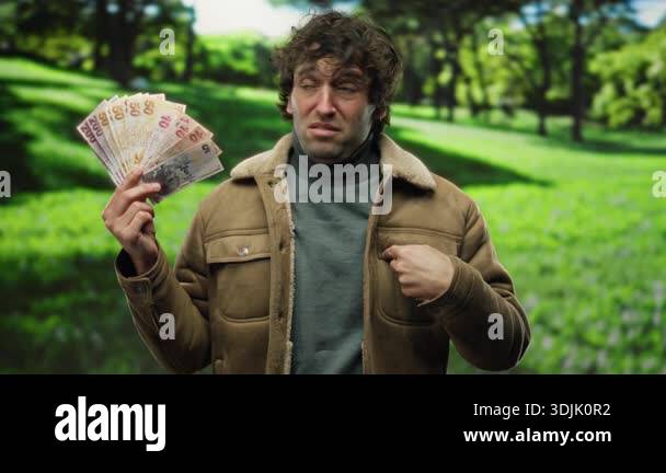 Hispanic man outdoors in a park pointing to himself and holding turkish ...